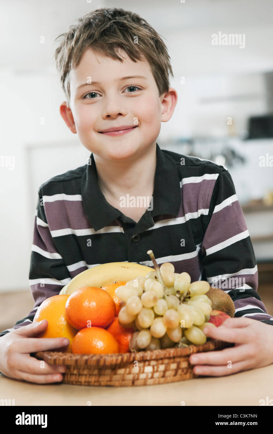 Germany, Cologne, Boy with basket of fruits, portrait Stock Photo - Alamy