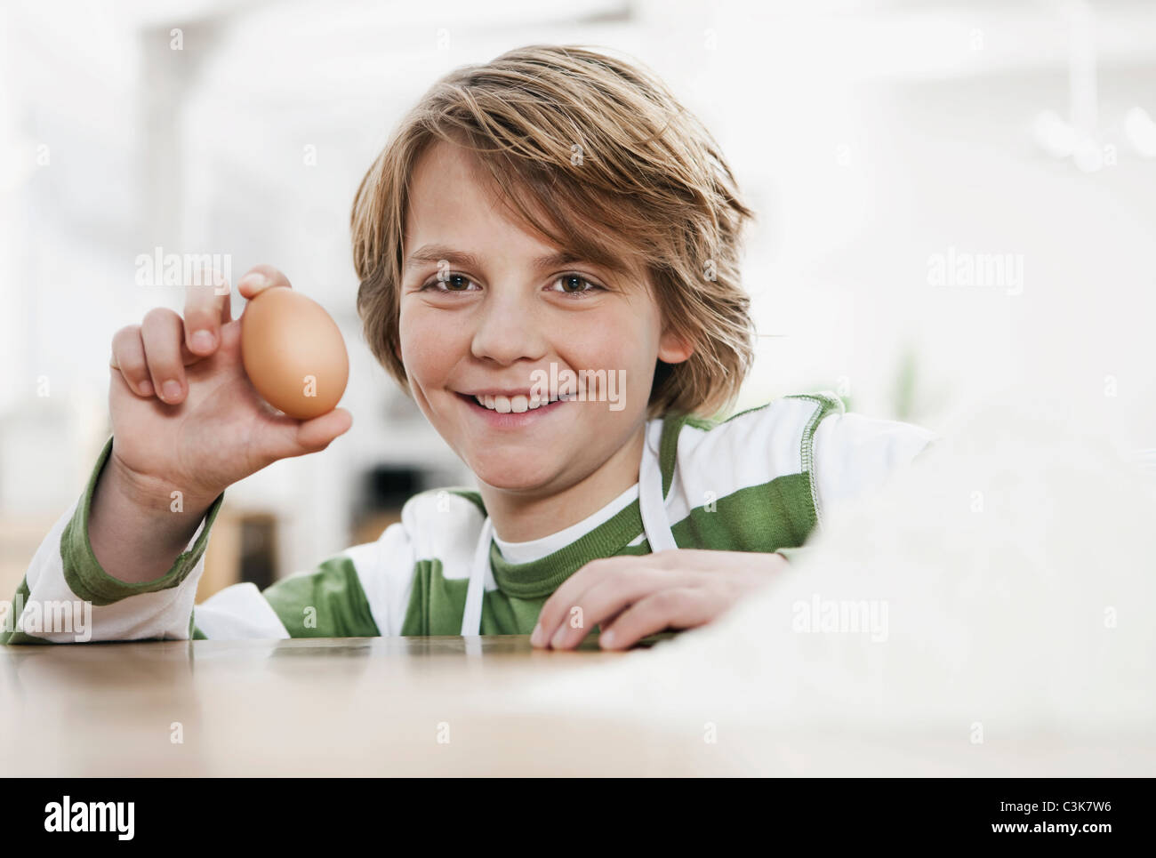 Germany, Cologne, Boy holding egg, smiling, portrait Stock Photo - Alamy