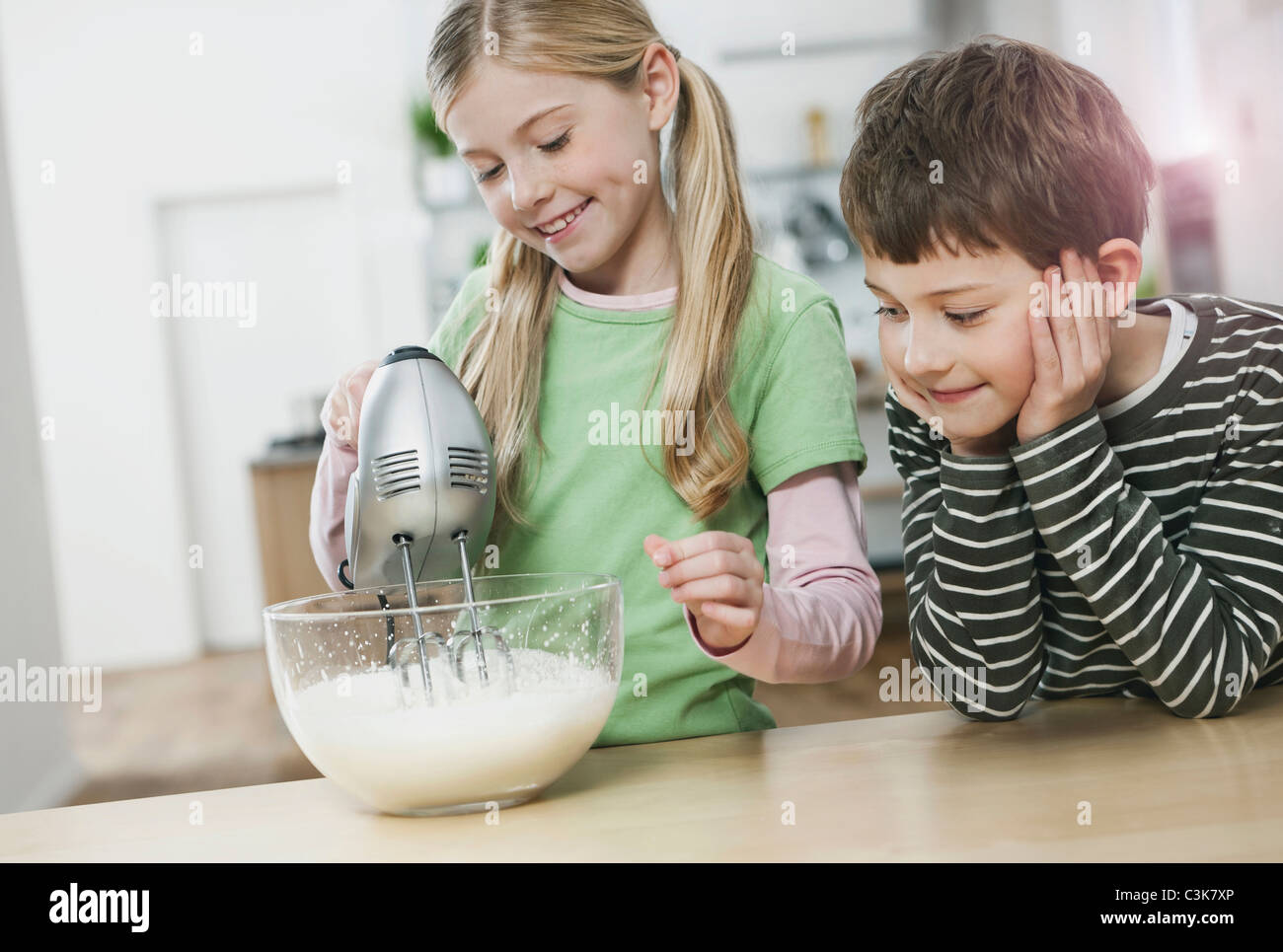 Germany, Cologne, Girl and boy mixing batter using electric whisk Stock ...