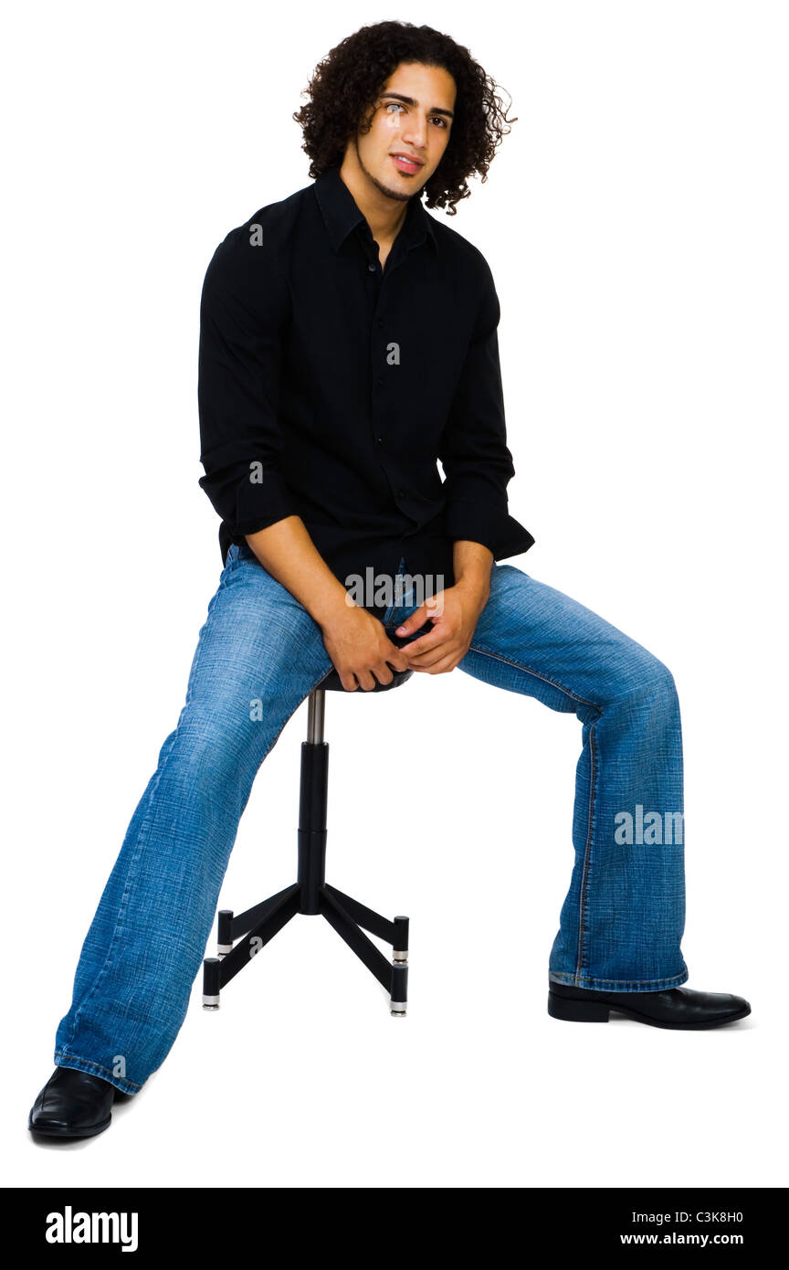 Man sitting on a stool and posing isolated over white Stock Photo - Alamy
