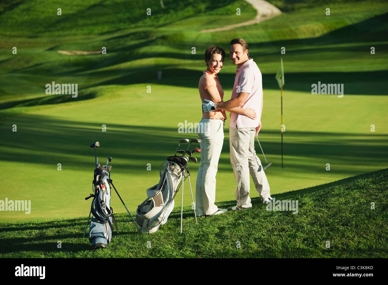 Italy, Kastelruth, Mid adult couple on golf course, smiling, portrait ...