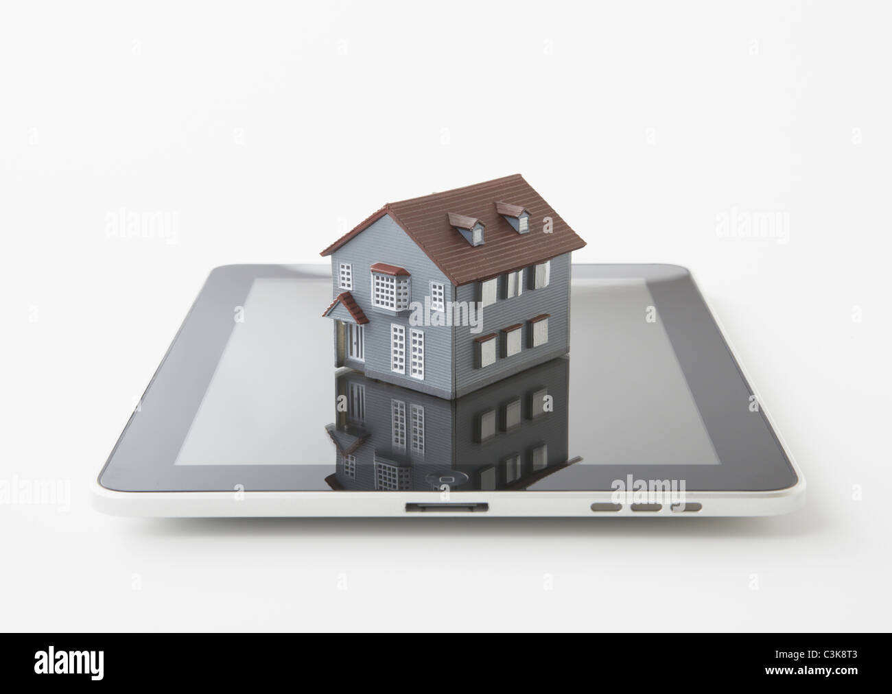 Tablet PC and miniature model house Stock Photo - Alamy