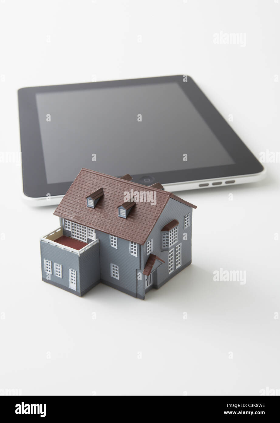 Tablet PC and miniature model house Stock Photo - Alamy