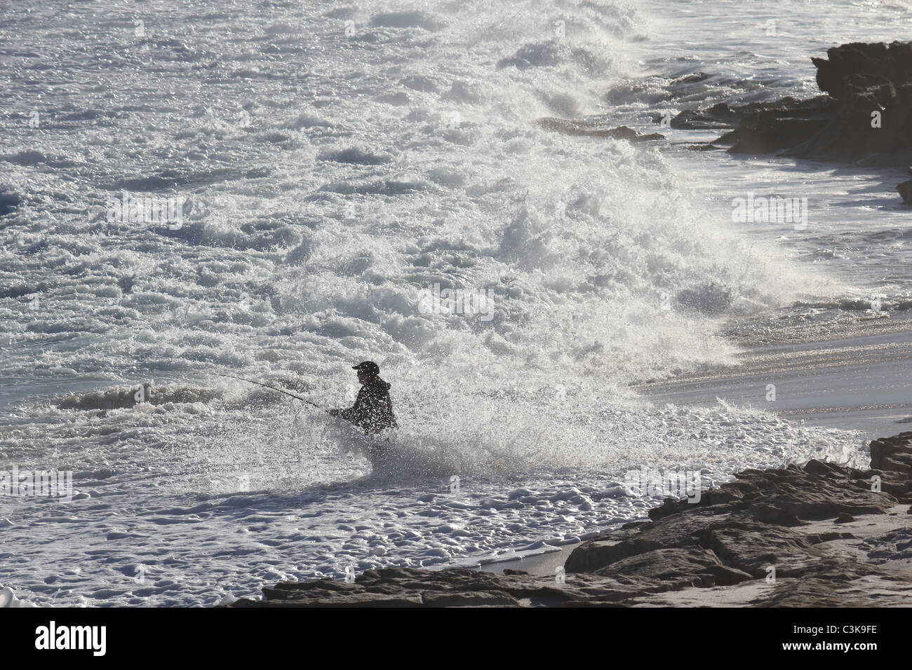 Fishing in the waves Stock Photo - Alamy