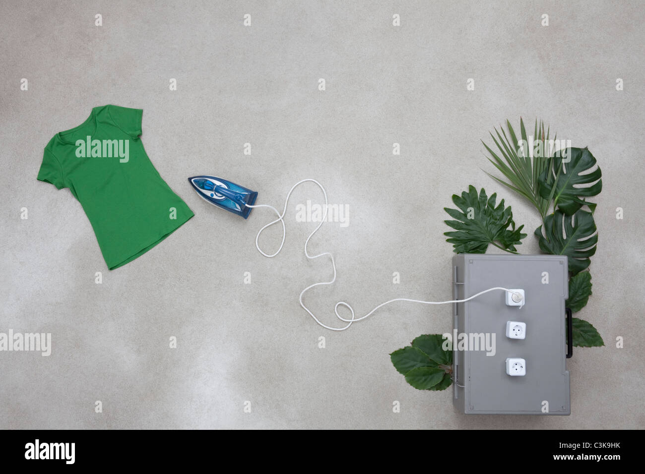 Iron connection to electric sockets with leaves, t-shirt on gray ...