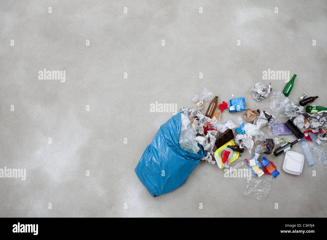 Garbage spilling from plastic bag on gray background Stock Photo - Alamy