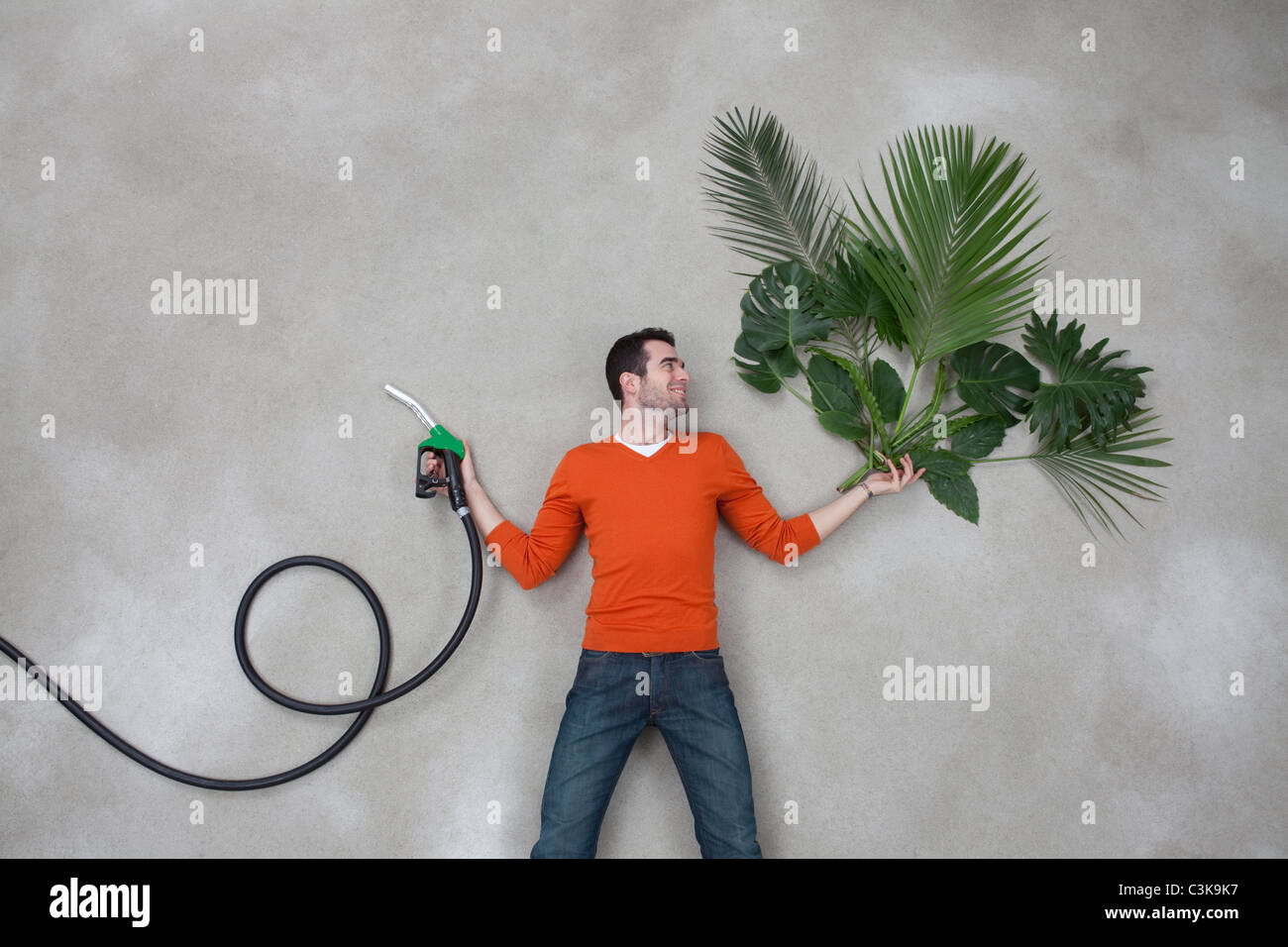 Young man holding industrial hose with plant Stock Photo - Alamy