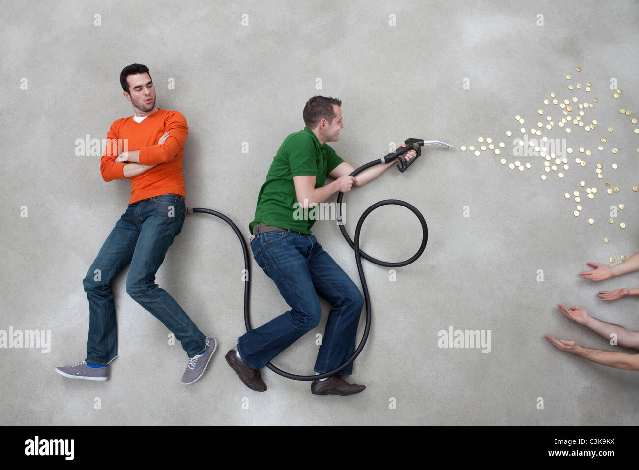 Human hands catching coins falling from industrial hose with man in ...