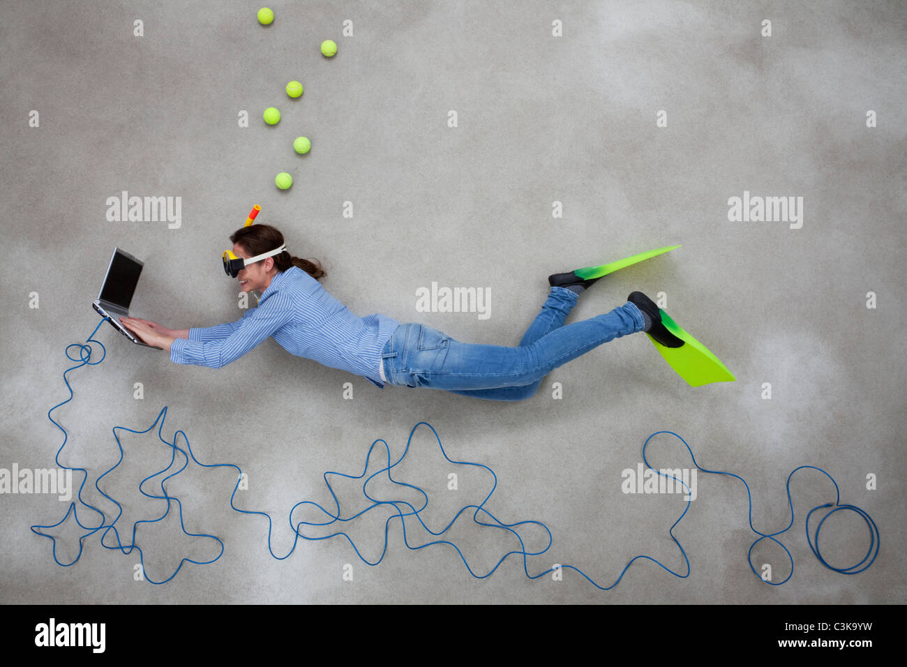 Mid adult woman diving and using laptop Stock Photo - Alamy