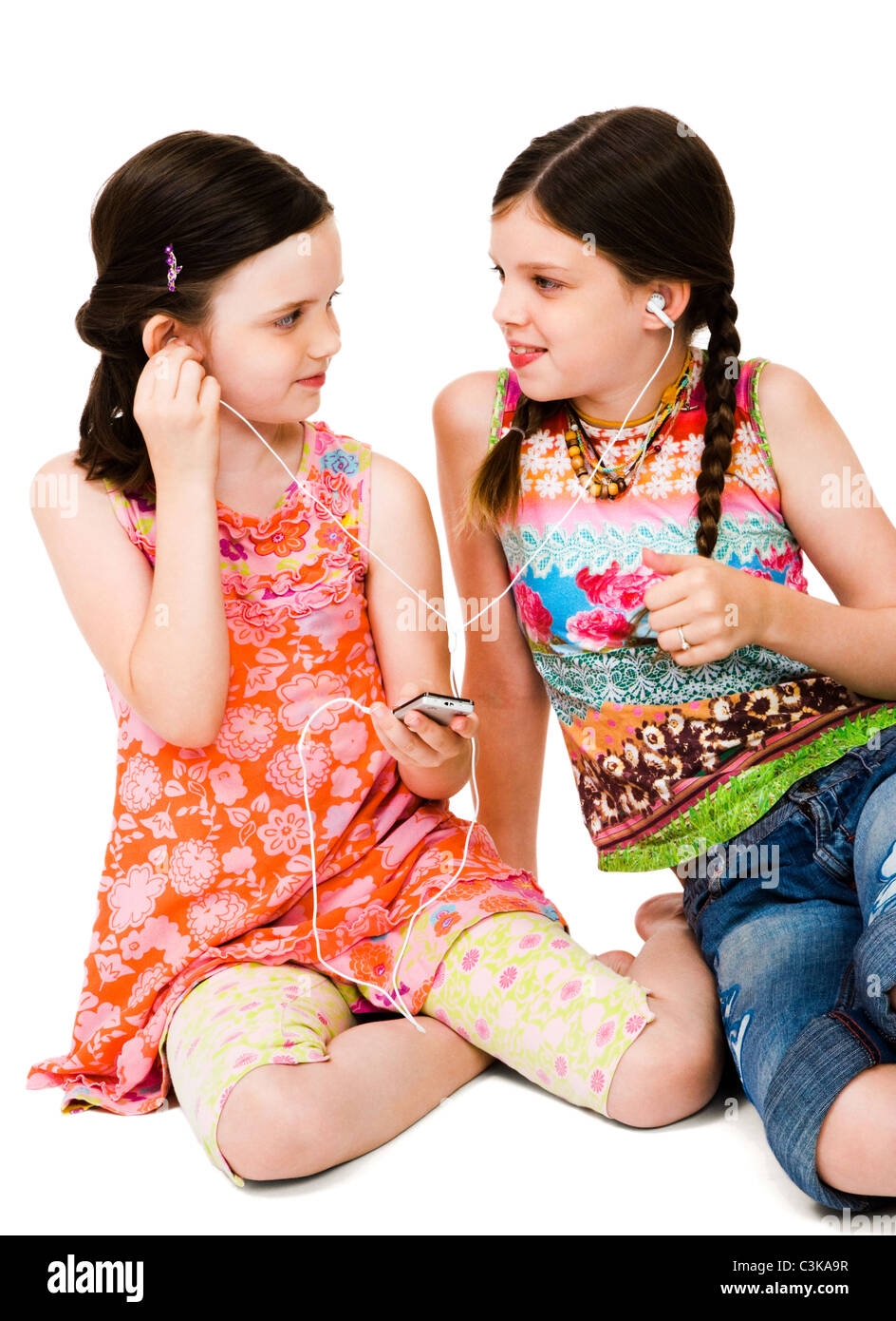 Girls listening to MP3 player and smiling isolated over white Stock ...