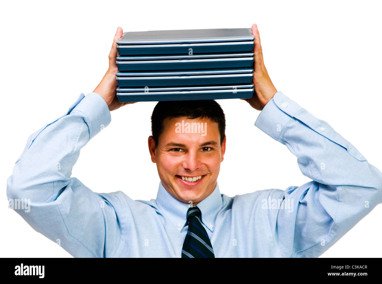 Smiling businessman holding a stack of laptops isolated over white ...
