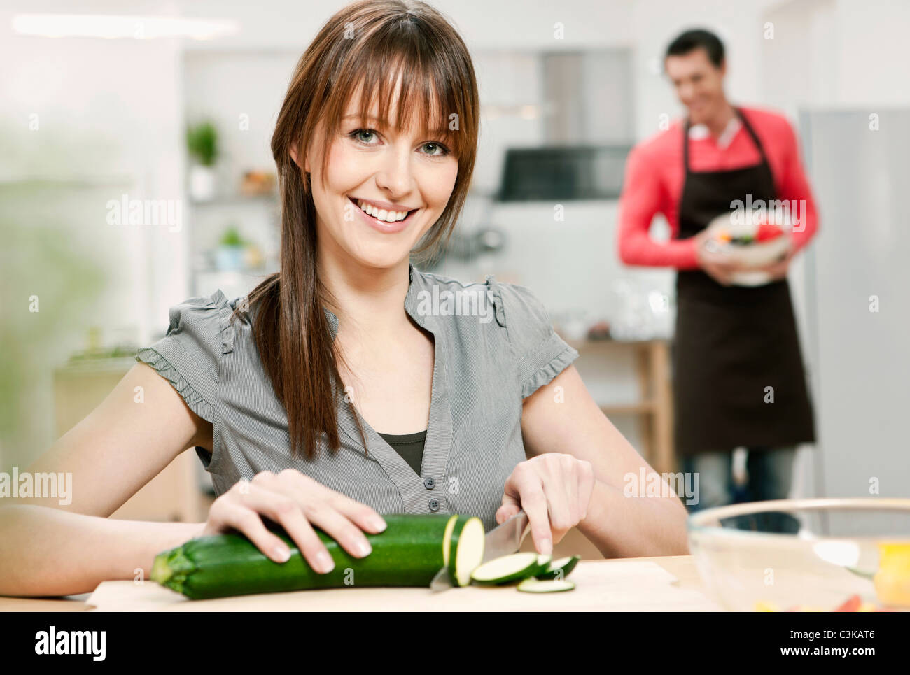 Germany, Cologne, Woman chopping cucumber in kitchen Stock Photo - Alamy