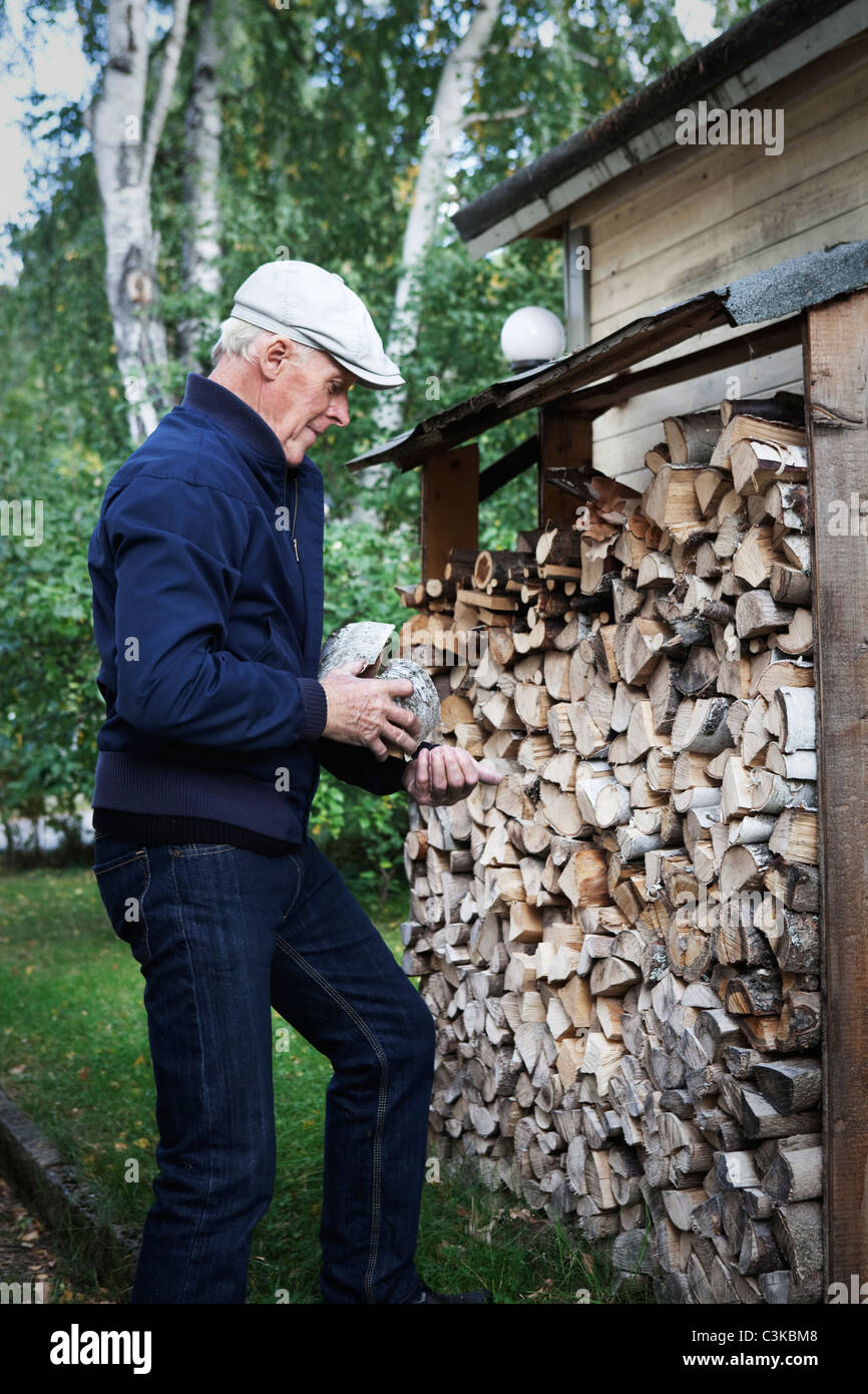 Senior man holding firewood hi-res stock photography and images - Alamy
