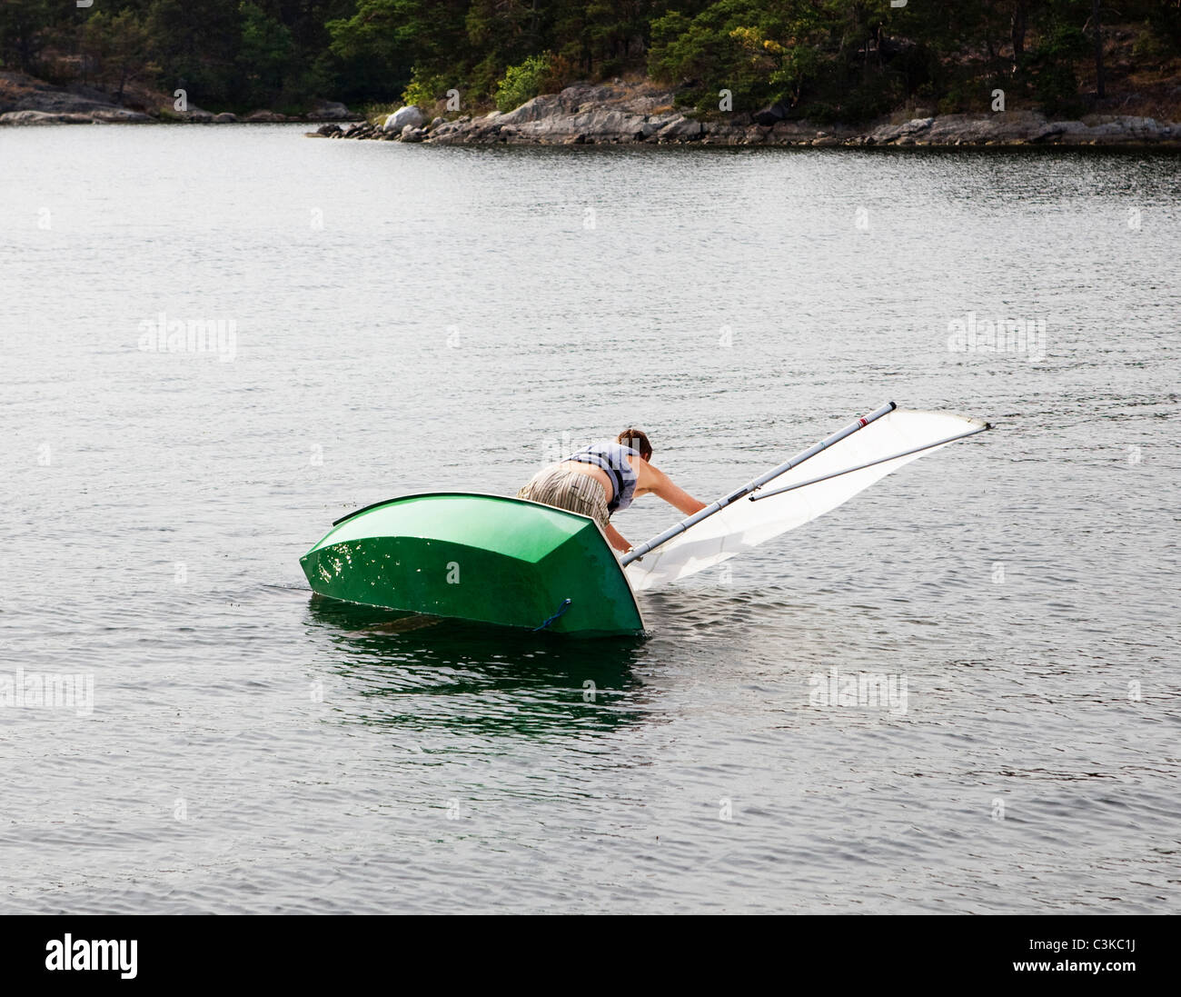 Man and dinghy falling into water Stock Photo - Alamy