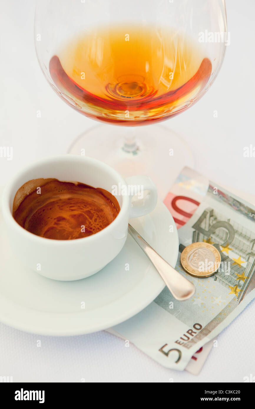 Glass of cognac and coffee with coin and Euro notes Stock Photo - Alamy