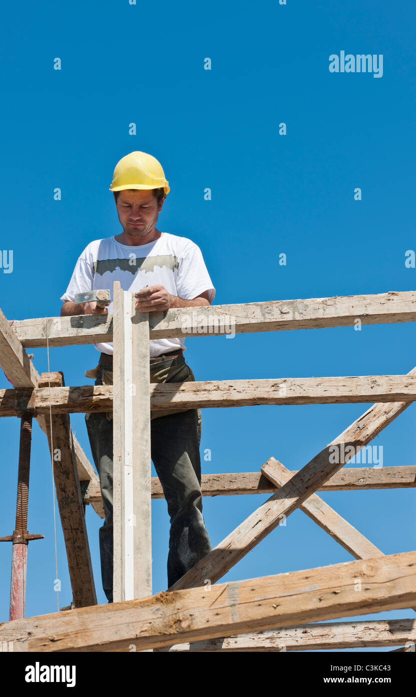 Construction worker on scaffold busy with formwork preparation Stock ...