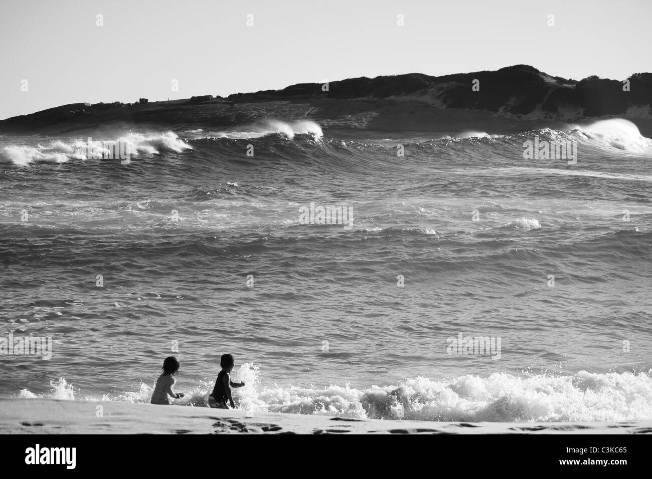 Kids running from waves Stock Photo - Alamy