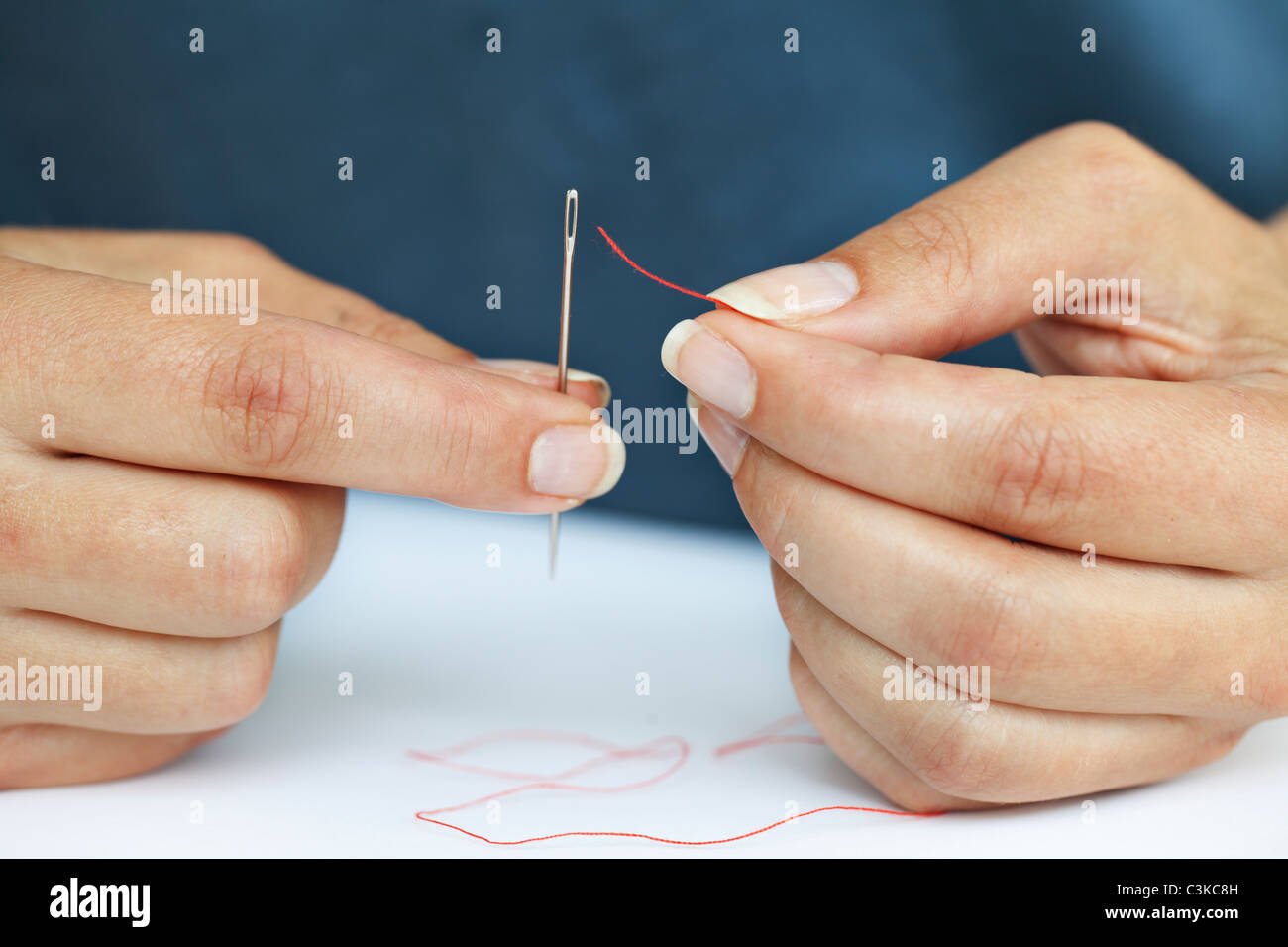 Woman threading needle, close-up Stock Photo - Alamy