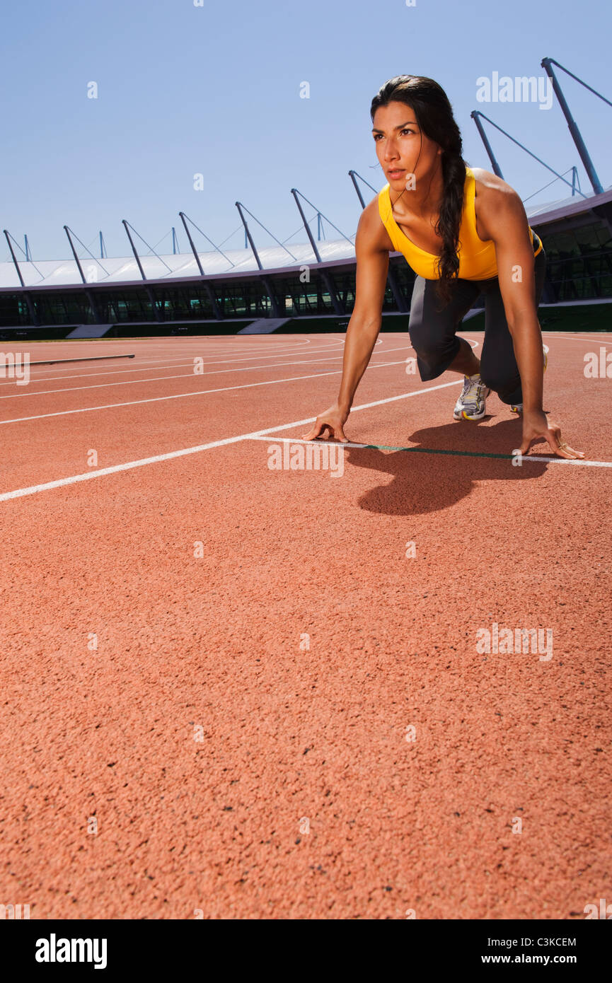 Female runners on starting block at stadium Stock Photo - Alamy