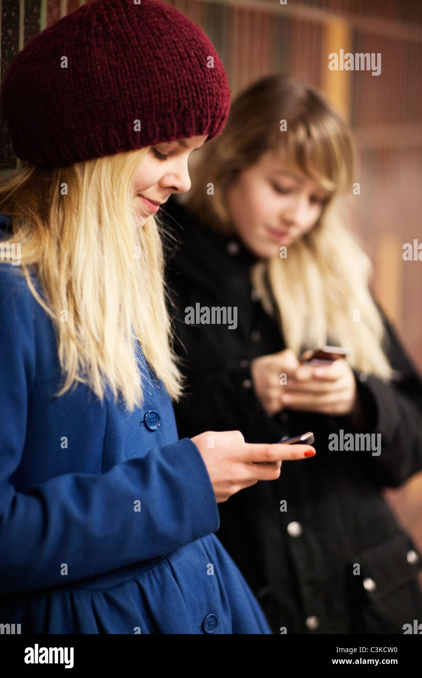 Two teenage girls using cell phones Stock Photo - Alamy