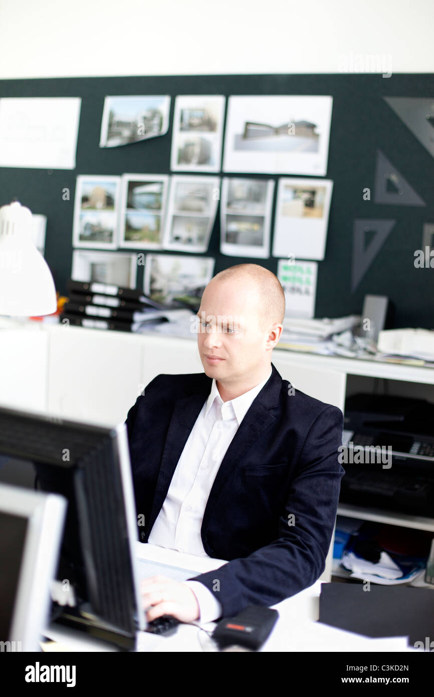 Man sitting in office using computer Stock Photo - Alamy