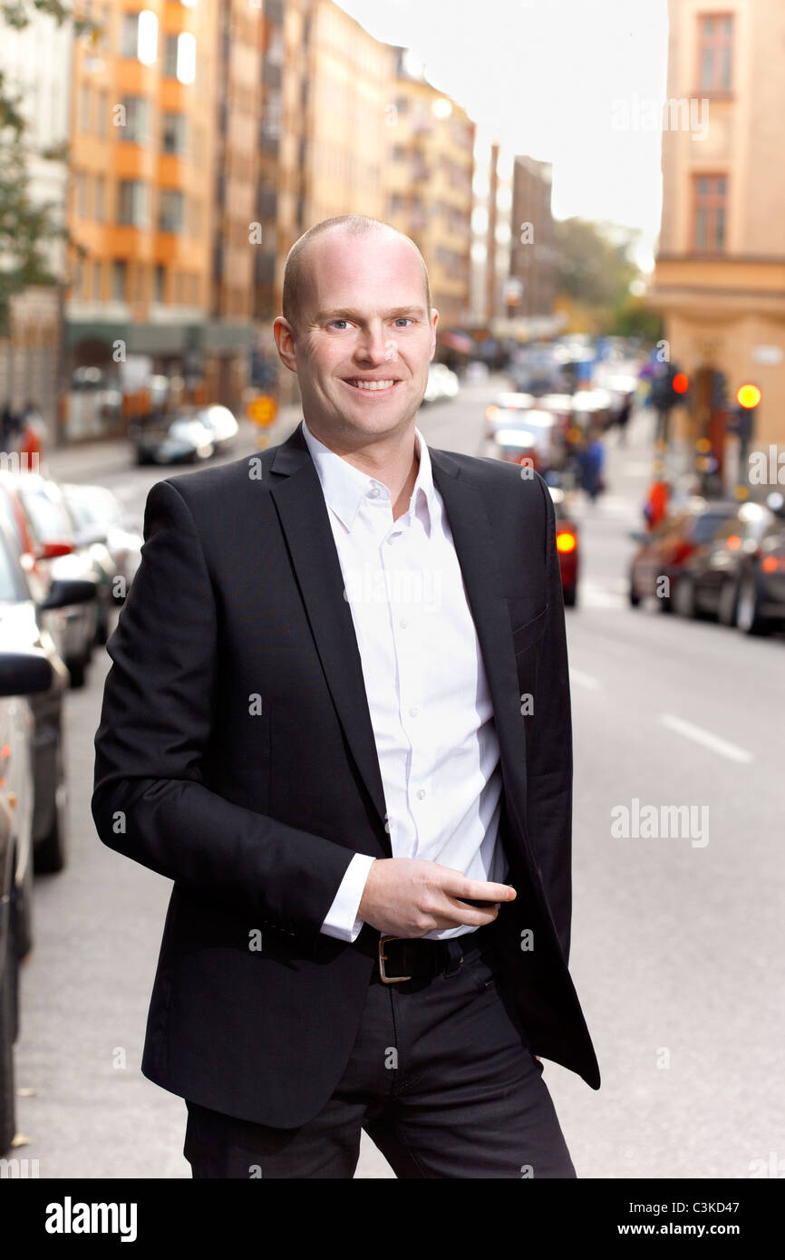 Man standing through city street, smiling, portrait Stock Photo - Alamy