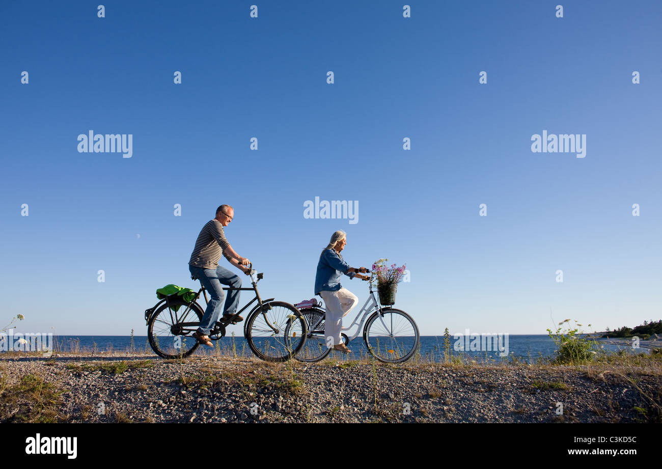 Mature couple riding bicycle on beach Stock Photo - Alamy