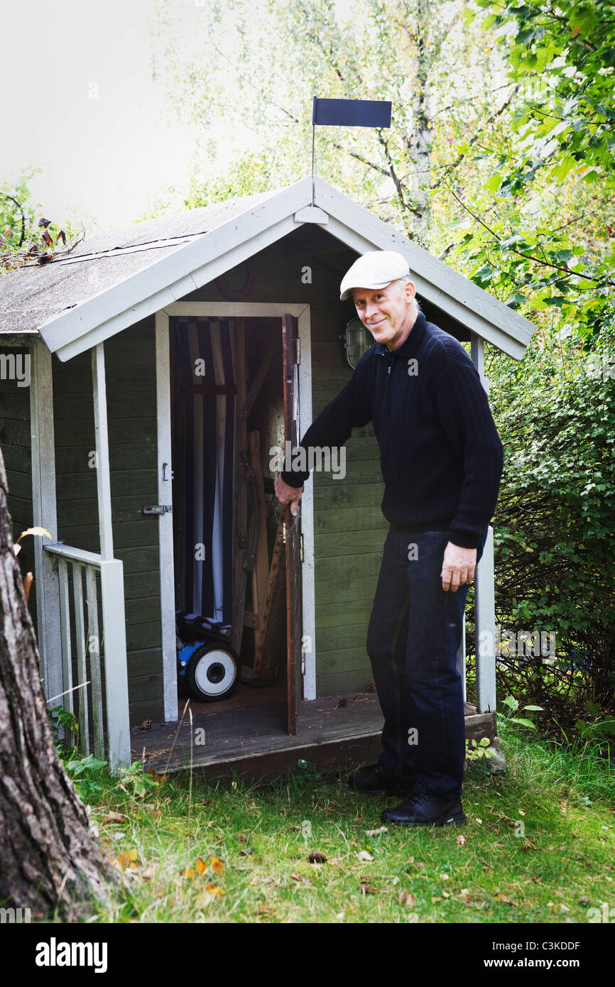 Senior man standing by shed in garden Stock Photo - Alamy