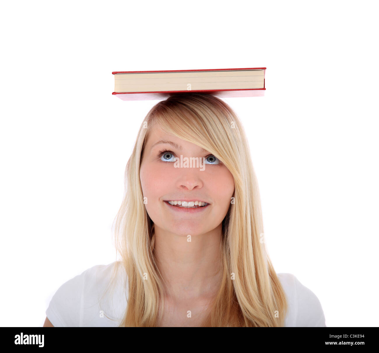 Attractive young woman balancing a book on her head. All on white ...
