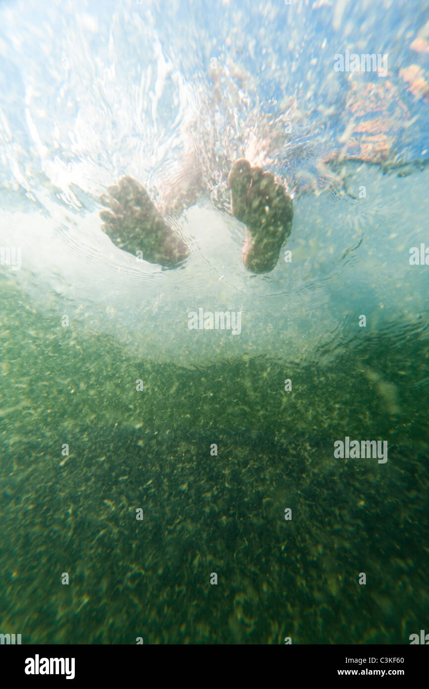 Low angle view of feet in water Stock Photo - Alamy