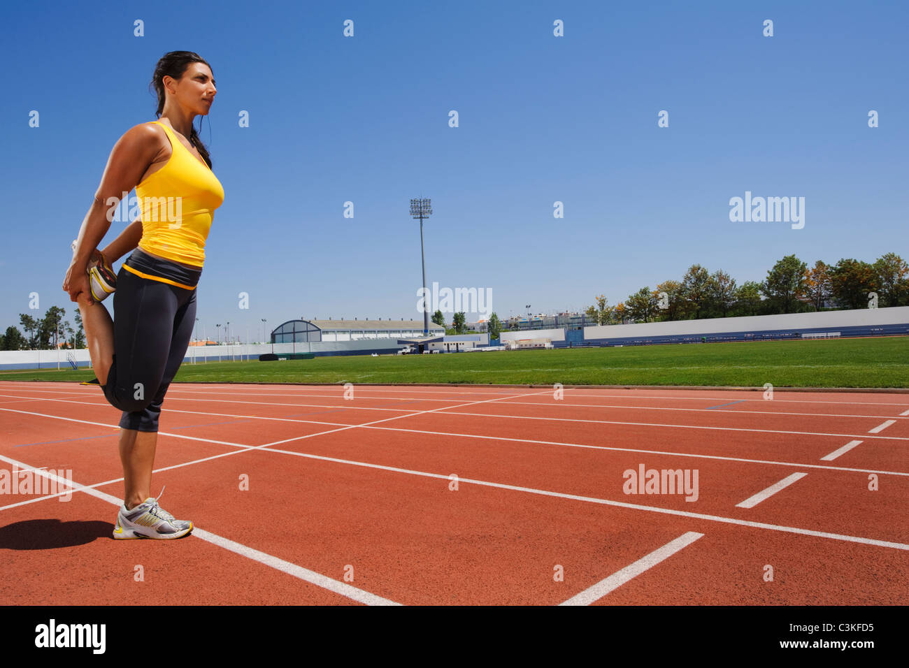 Female athlete stretching at stadium Stock Photo - Alamy
