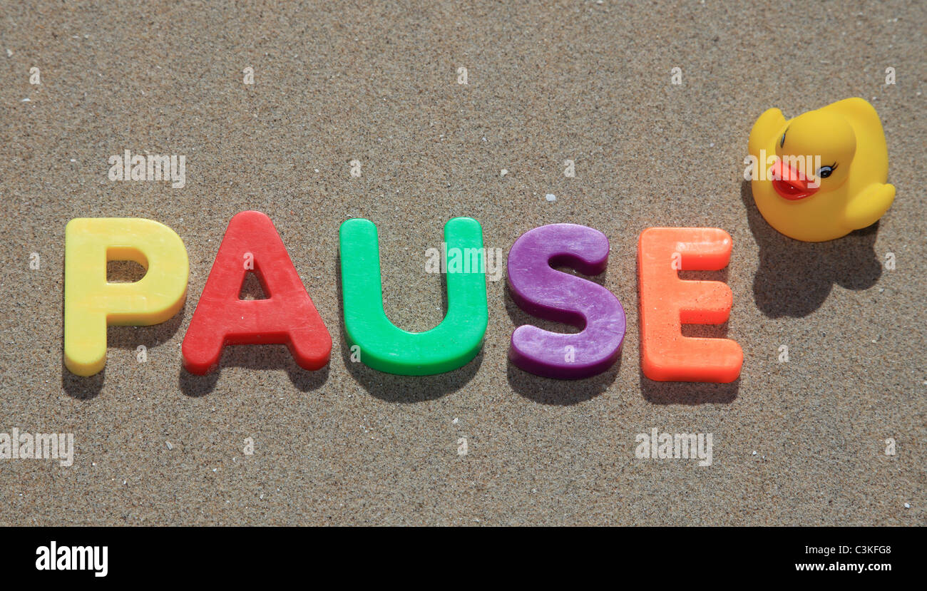 The term pause in colorful letters on sand Stock Photo - Alamy