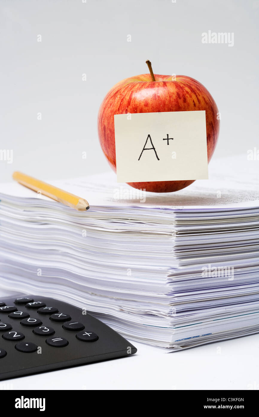 An apple on a stack of paper, close-up Stock Photo - Alamy