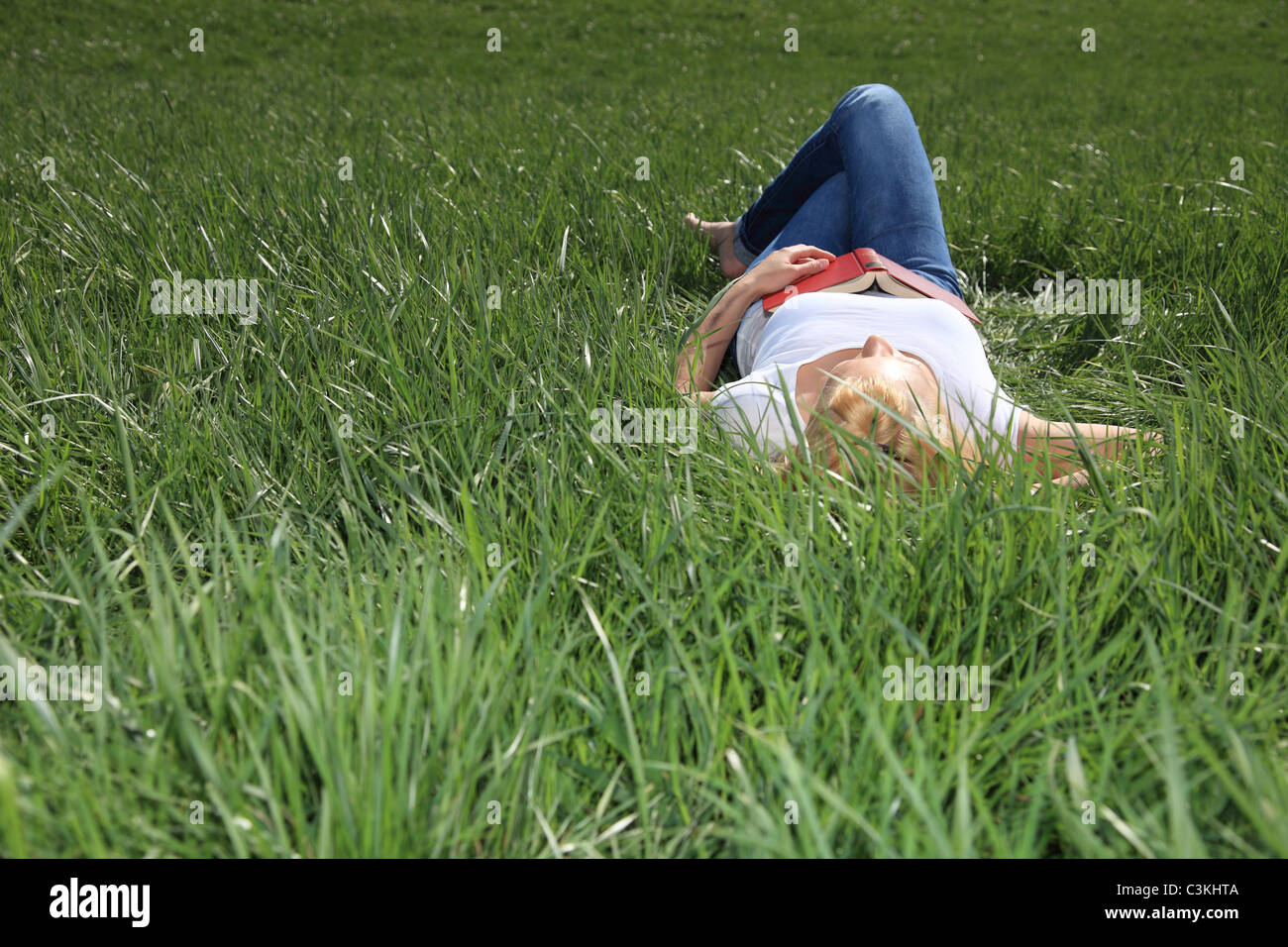 Woman taking nap on grass hi-res stock photography and images - Alamy