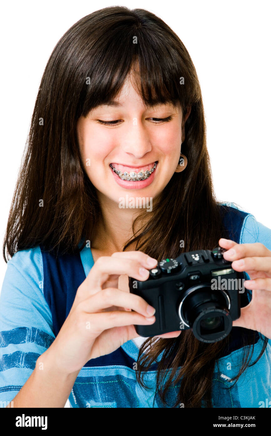 Teenager photographing with a camera and smiling isolated over white ...