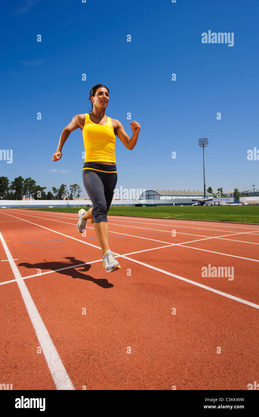 Female athlete sprinting at stadium Stock Photo - Alamy