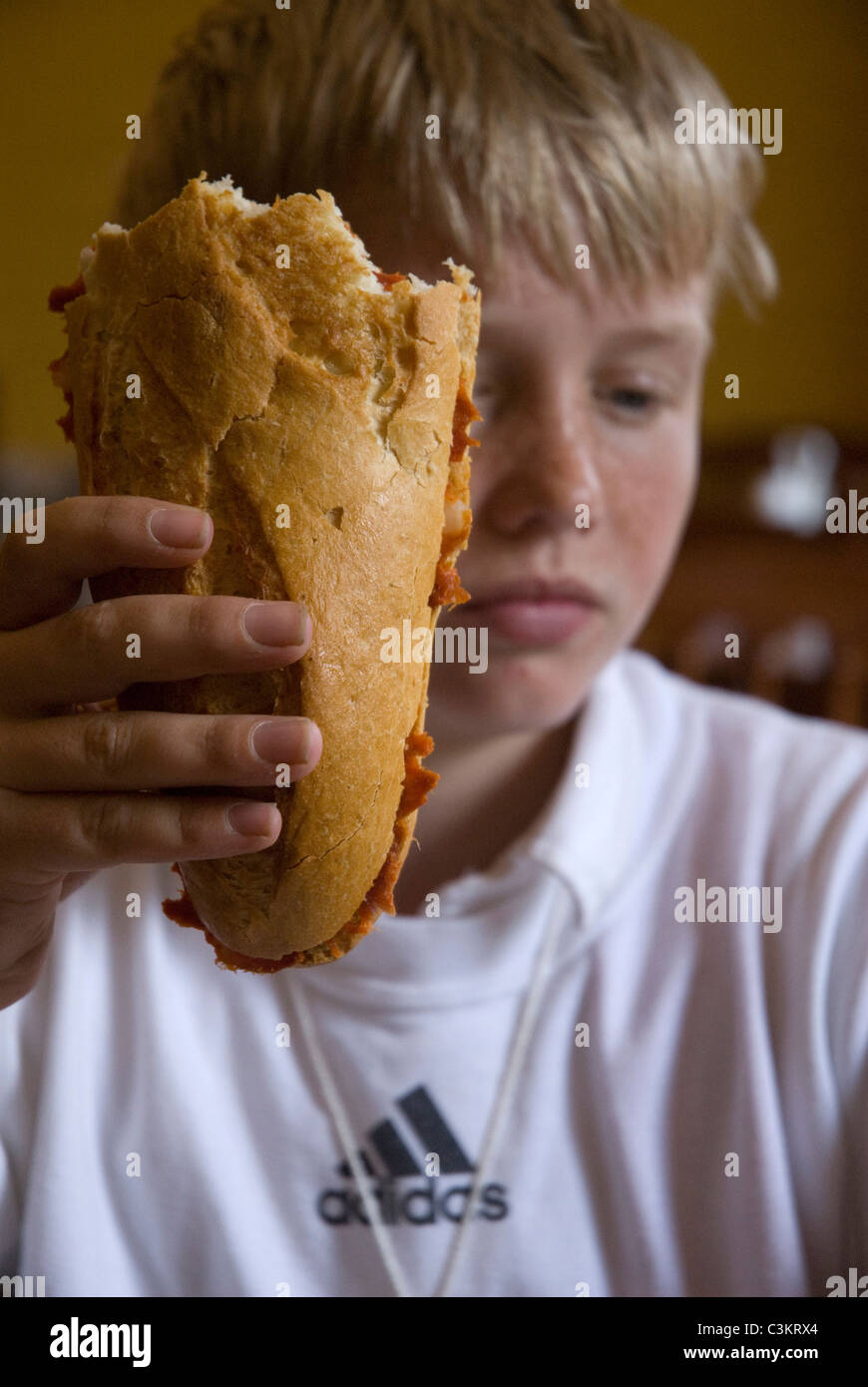 Boy eating a baguette Stock Photo - Alamy
