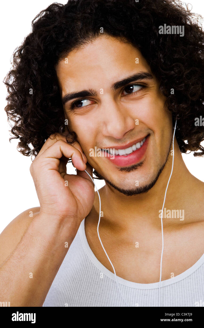 Fashion model listening to music on a MP3 player isolated over white ...