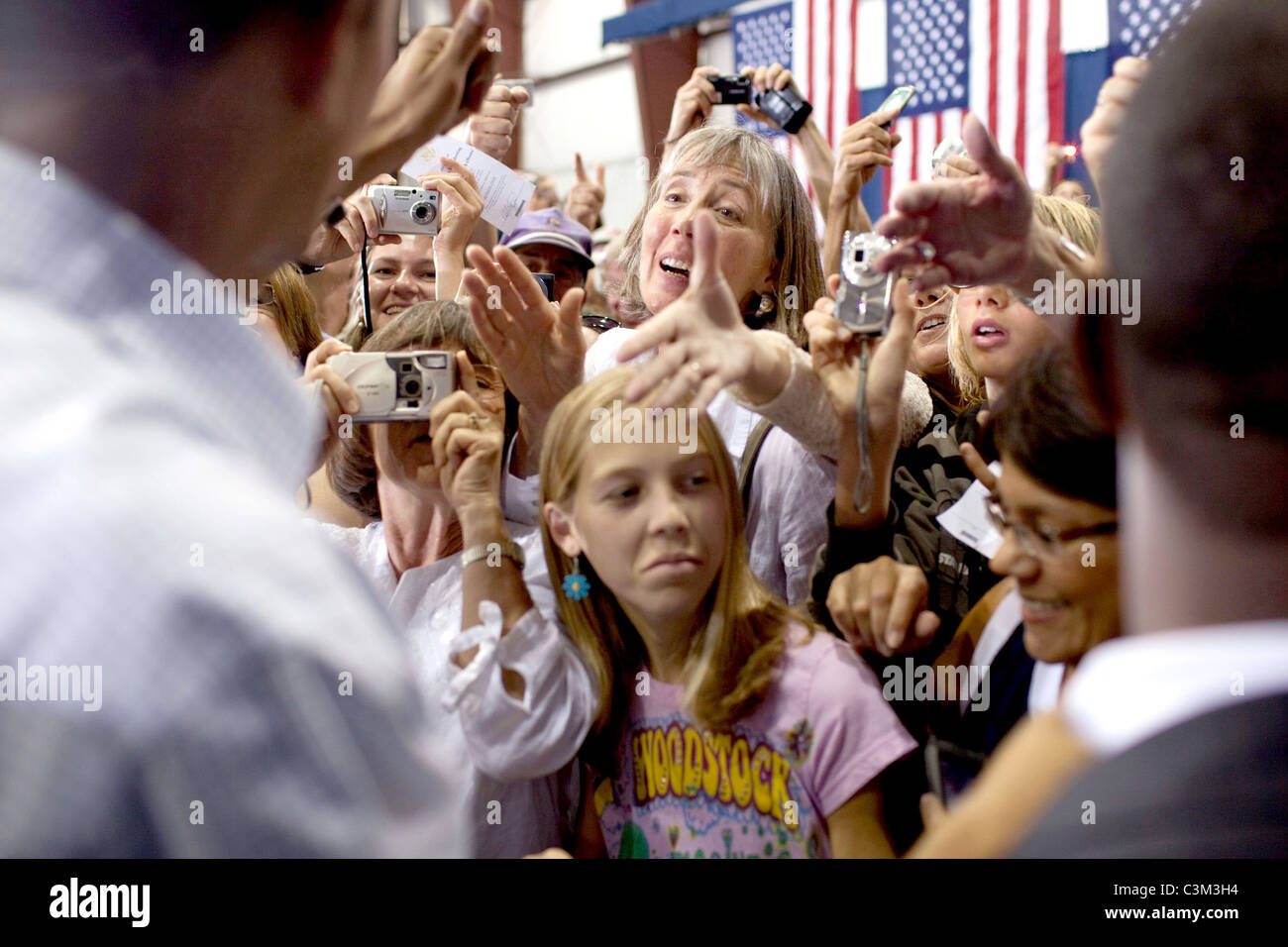 People in the audience reach out to shake hands with President Barack ...