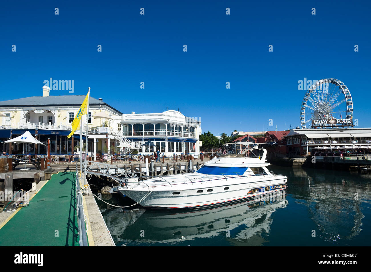 Jetty and boat in the harbour at V&A Waterfront with Wheel of ...