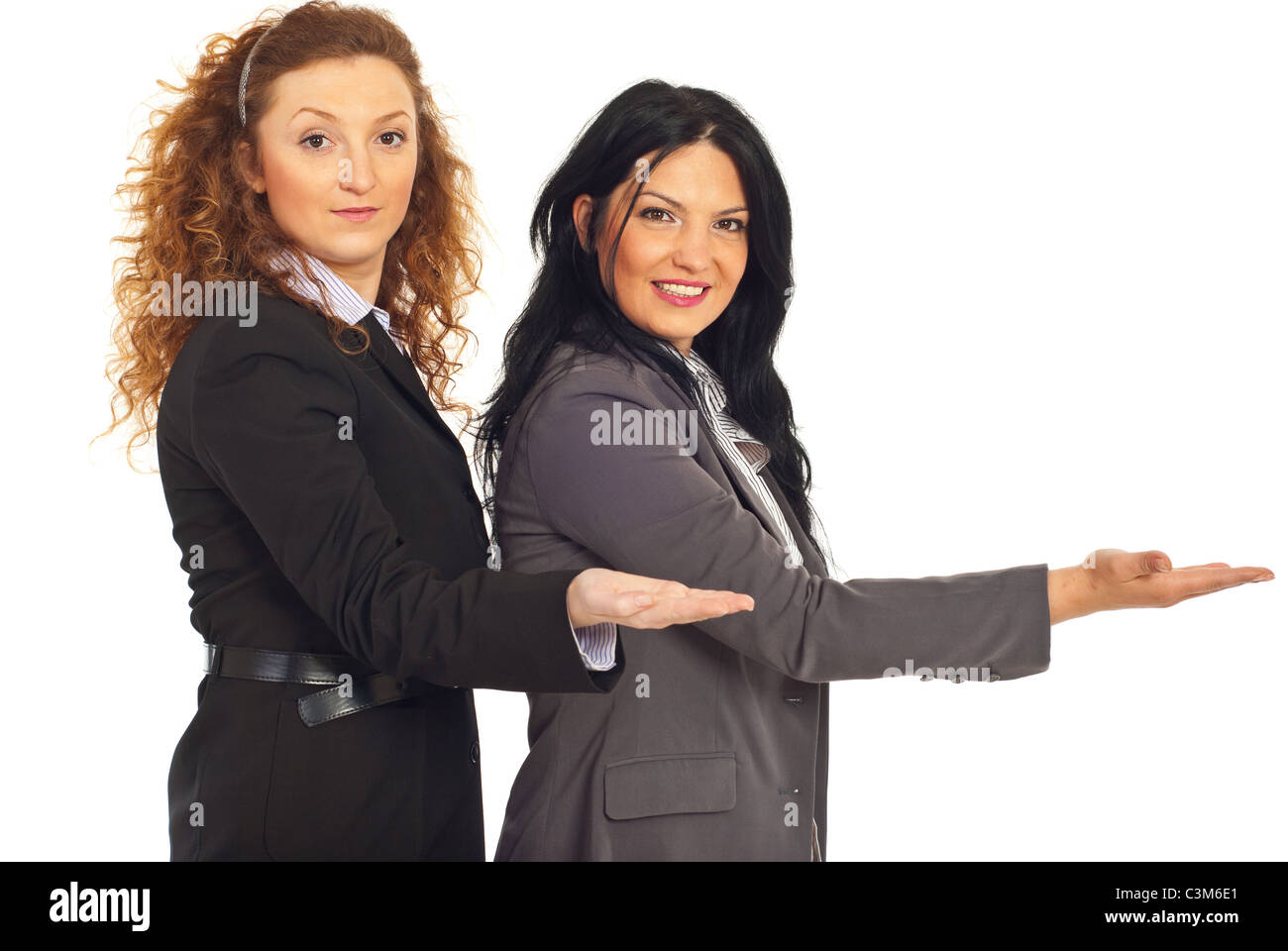 Two beauty business women welcoming with hands to copy space isolated ...