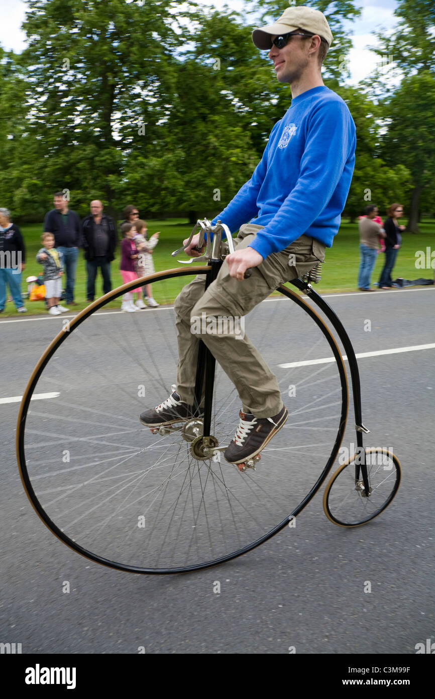 Man riding a restored / reconditioned Penny Farthing bicycle on a ...