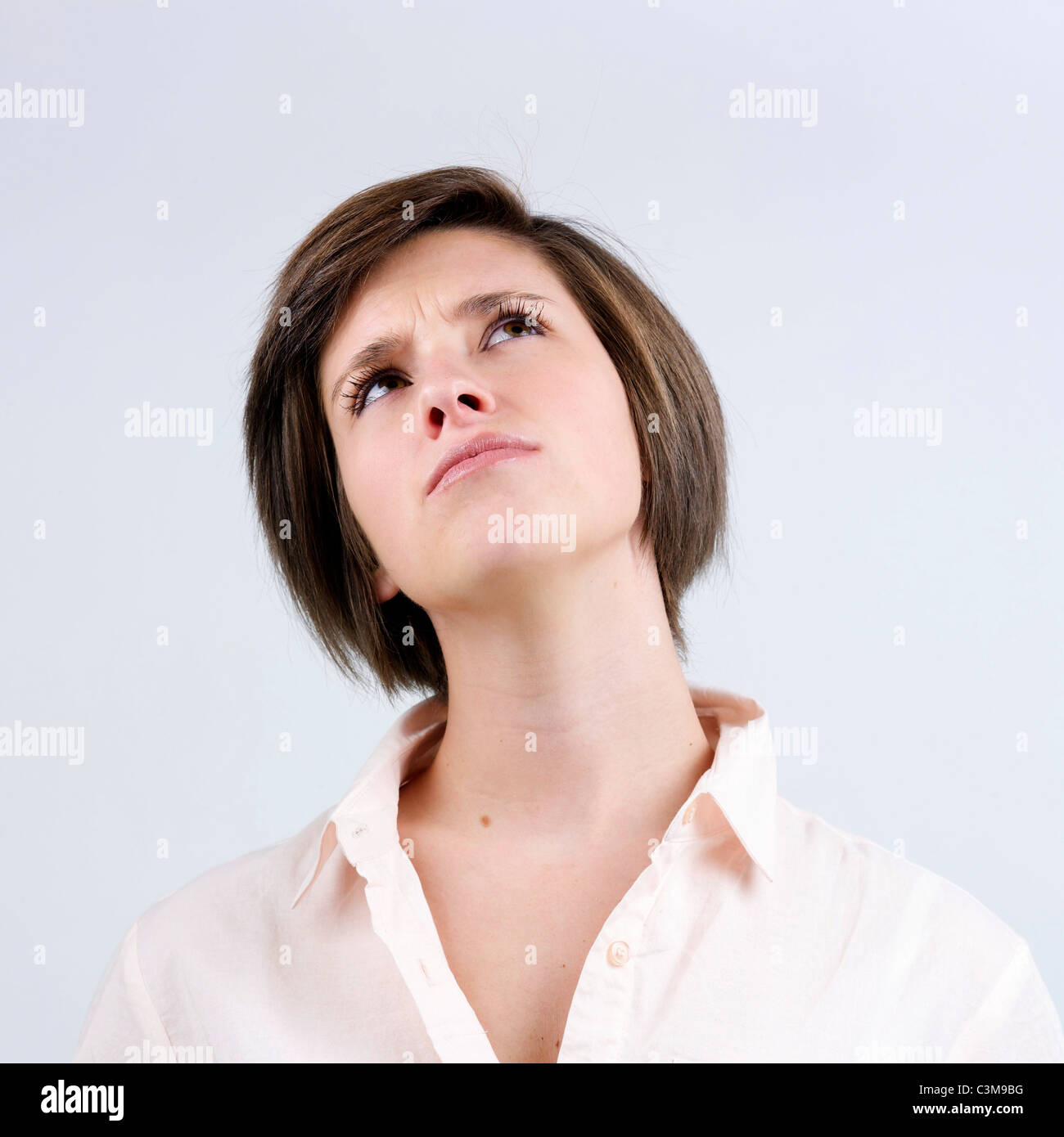 Young woman looking upwards - studio shot Stock Photo - Alamy