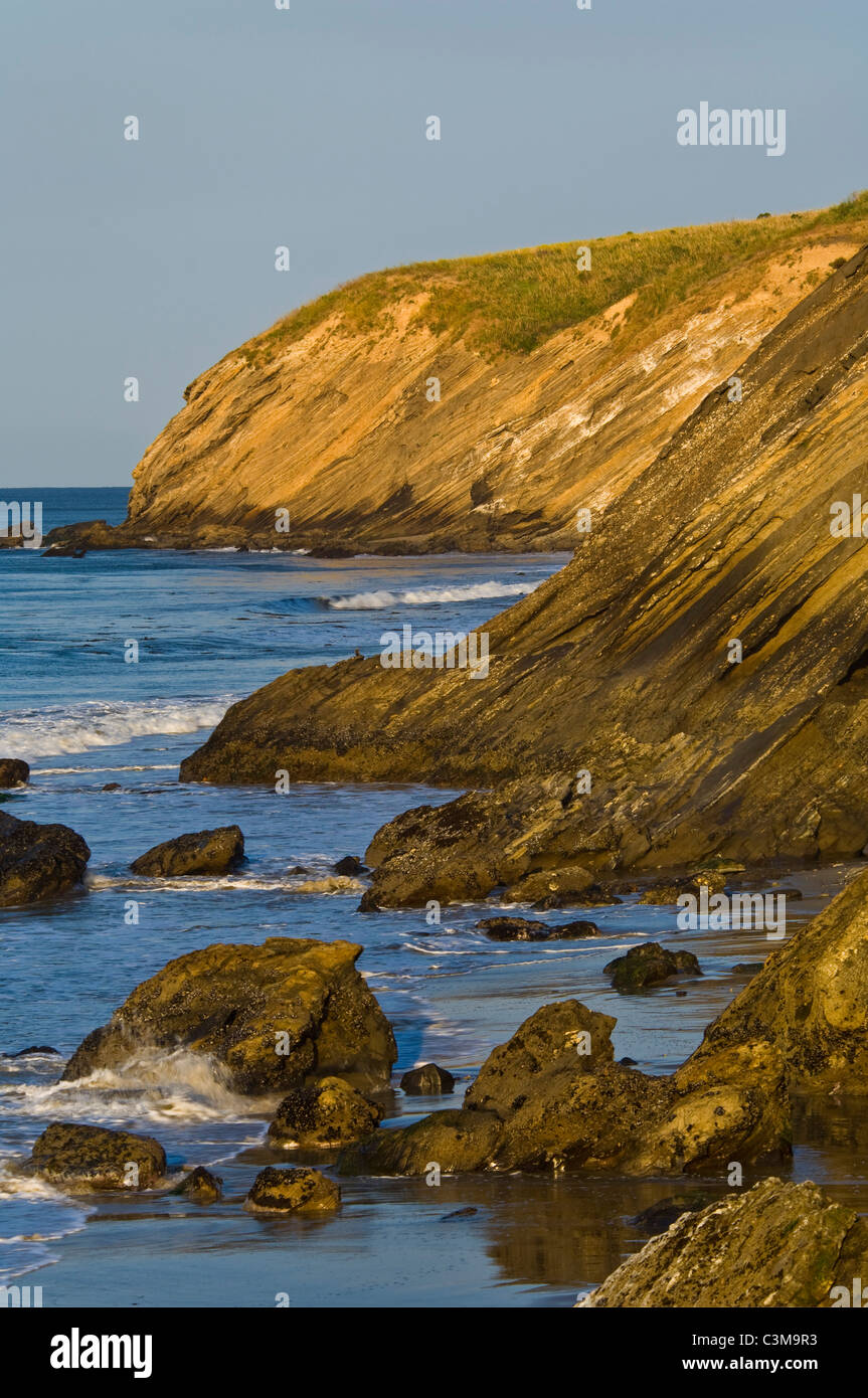 Striated cliffs of sedimentary rock showing uplift, on the coast at ...