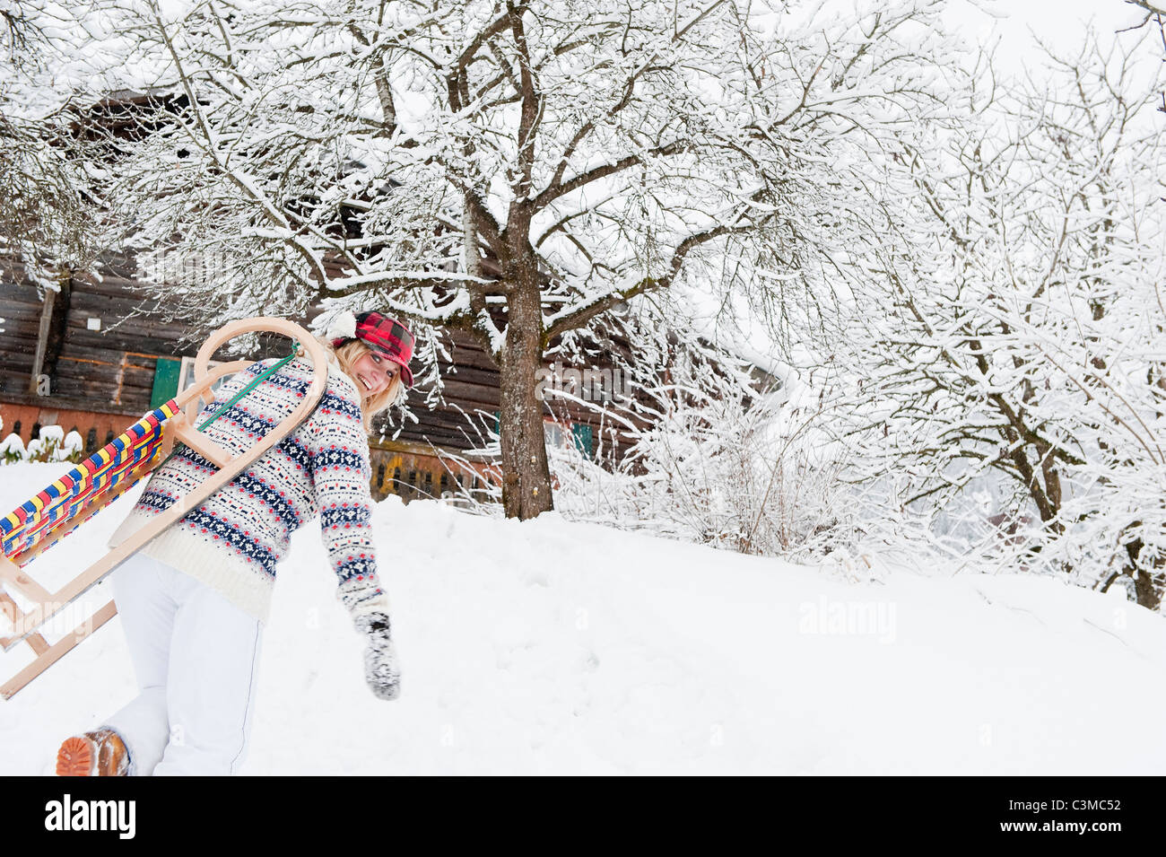 Austria, Salzburg, HÃ¼ttau, Young woman pulling sledge, smiling Stock ...
