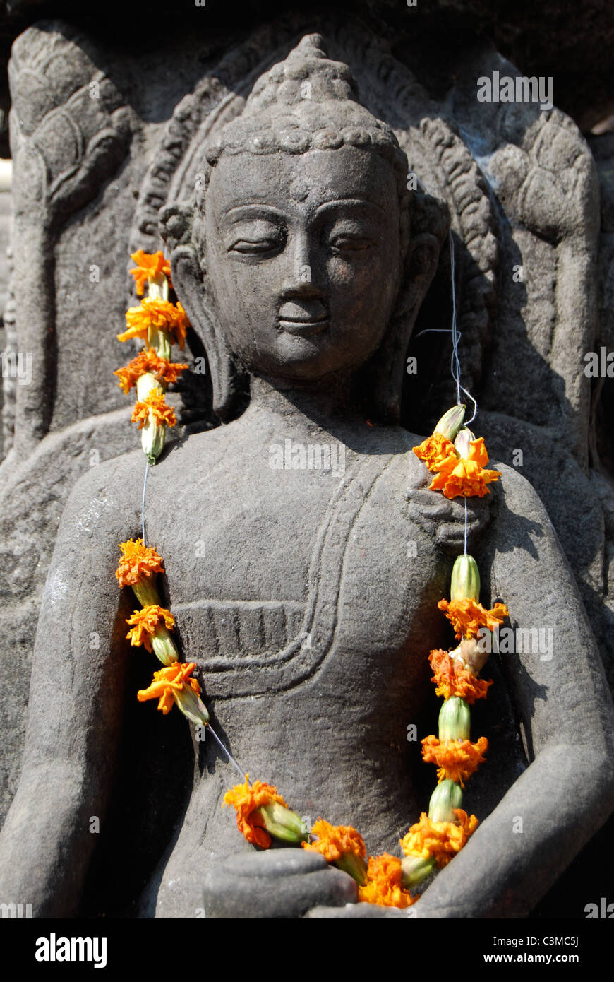 Religious idol with marigold garland Stock Photo - Alamy