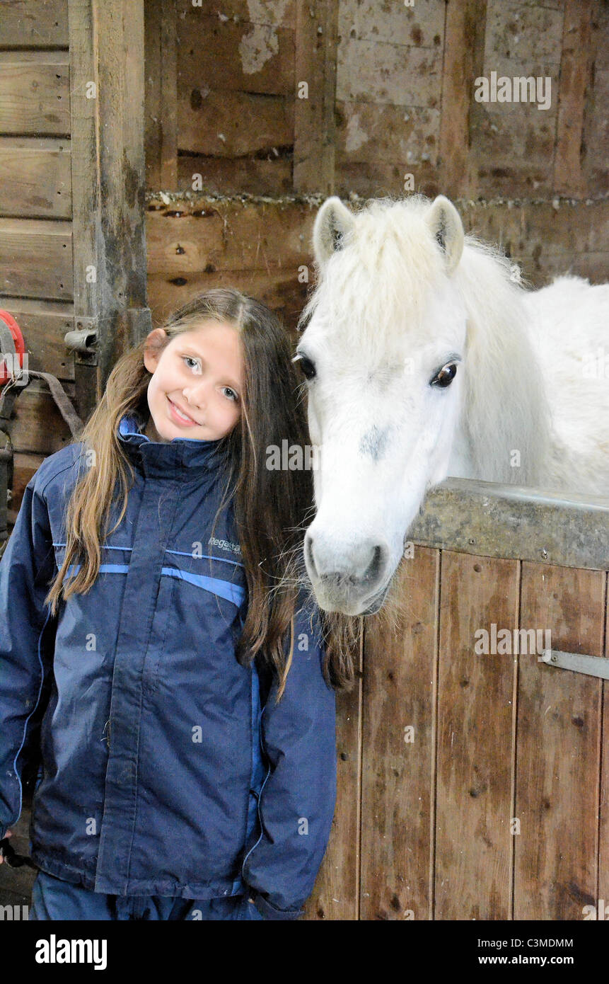White pony with girl in stable Stock Photo - Alamy