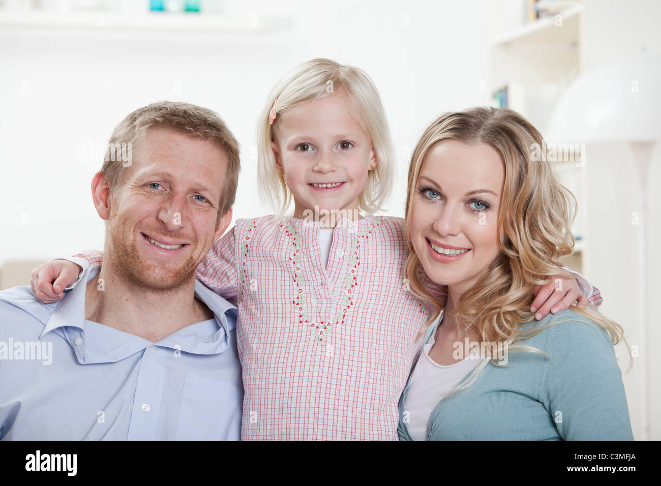 Germany, Bavaria, Munich, Daughter and parents at home, smiling ...