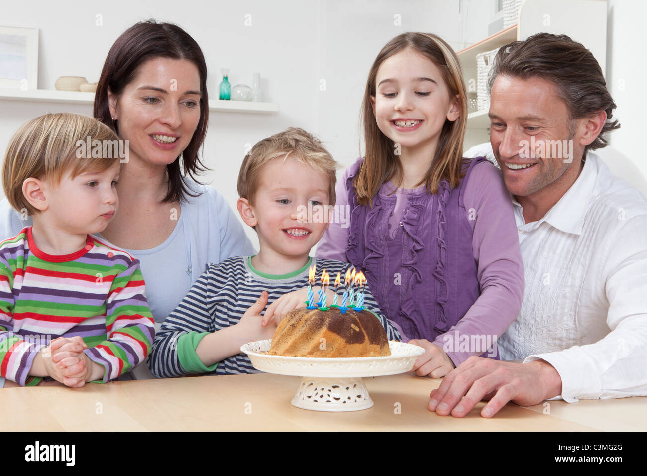 Germany, Bavaria, Munich, Family with birthday cake, smiling Stock ...