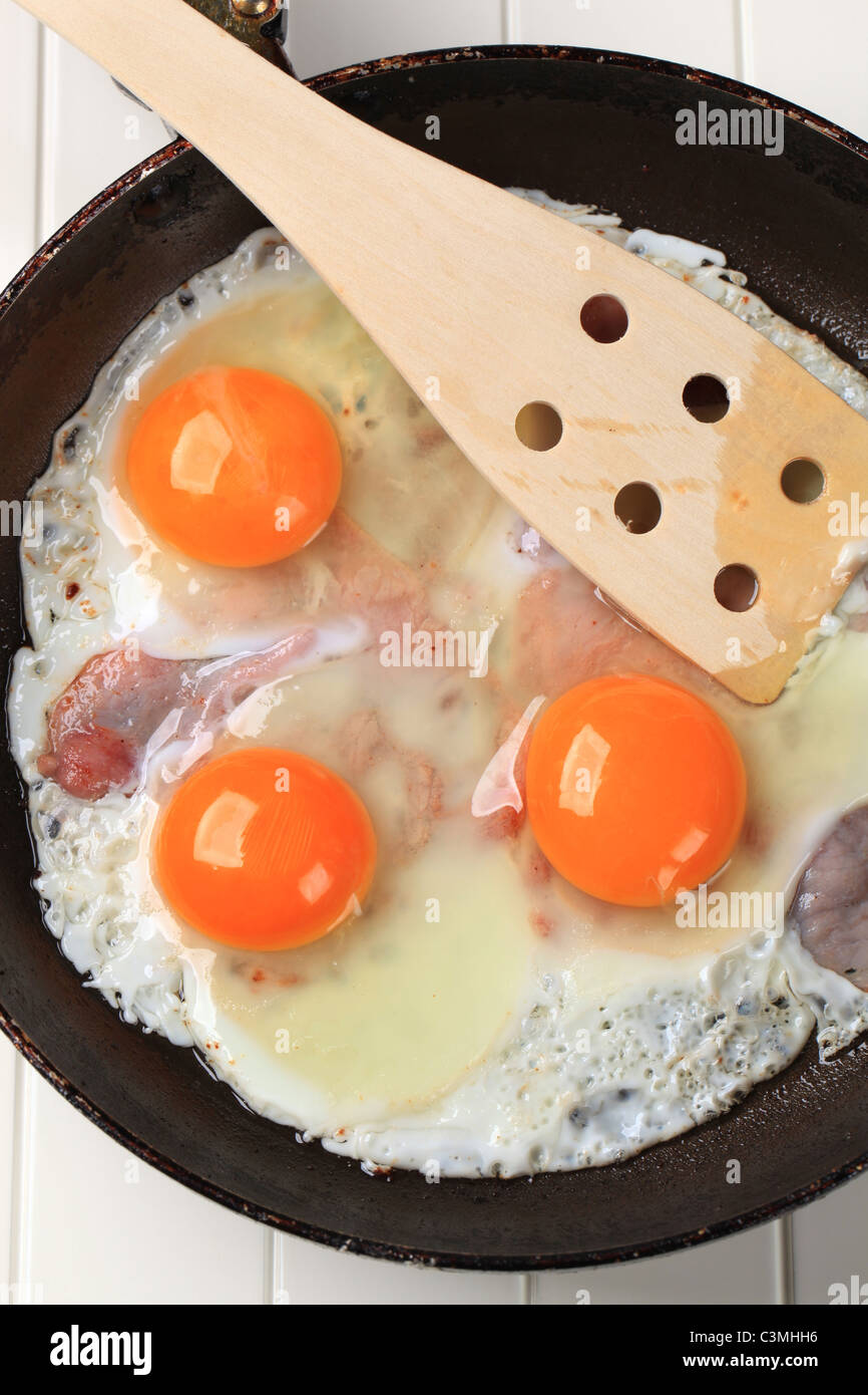 Preparing ham and eggs in a frying pan Stock Photo - Alamy